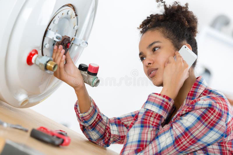 Female Worker Fixing Boiler Problem Stock Image - Image of tools, phone ...