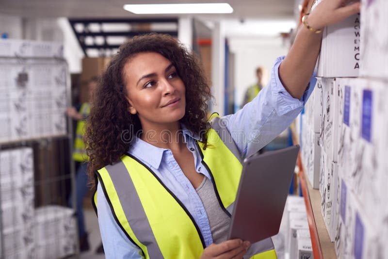 Female Worker Inside Busy Warehouse Checking Stock on Shelves Using ...