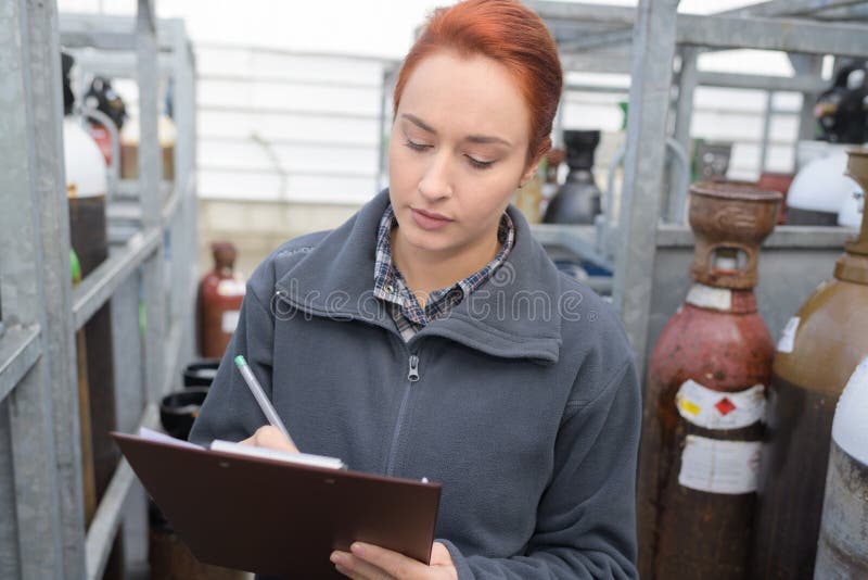 Female Worker Making Notes by Cages Gas Bottles Stock Image - Image of ...