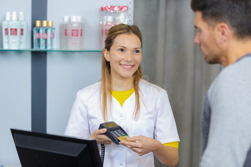 Female Worker in Uniform Taking Card Payment from Male Customer Stock ...