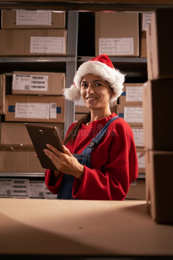 Female Worker Using Digital Tablet in Warehouse Stands between Boxes ...