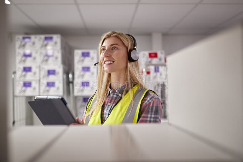 Female Worker Wearing Headset in Logistics Distribution Warehouse with ...