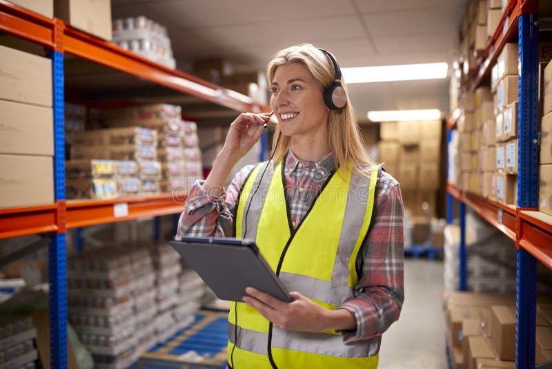 Female Worker Wearing Headset in Logistics Distribution Warehouse Using ...