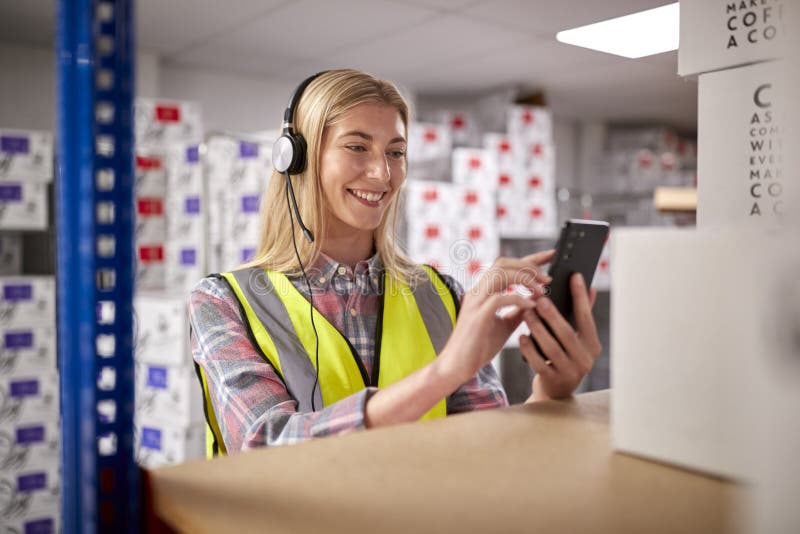Female Worker Wearing Headset in Logistics Distribution Warehouse Using ...