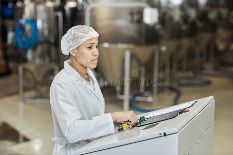 Female Worker Wearing Lab Coat Using Control Panel at Food Factory ...