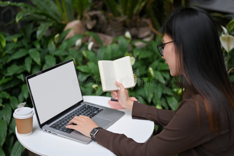 Female Worker Working with Laptop and Notebook on Round Table at Cafe ...