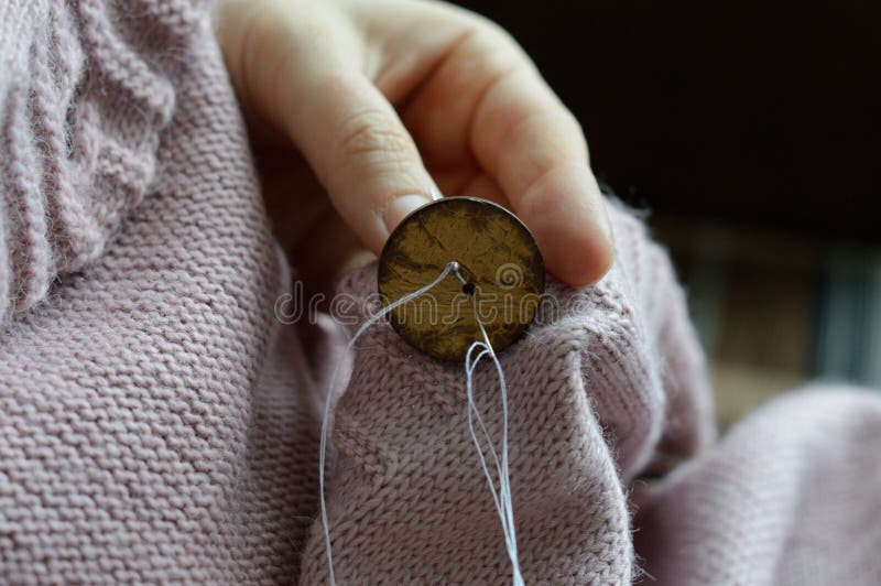 Female Workers Hands Sew a Wooden Button To a Jacket. Close-up Stock ...