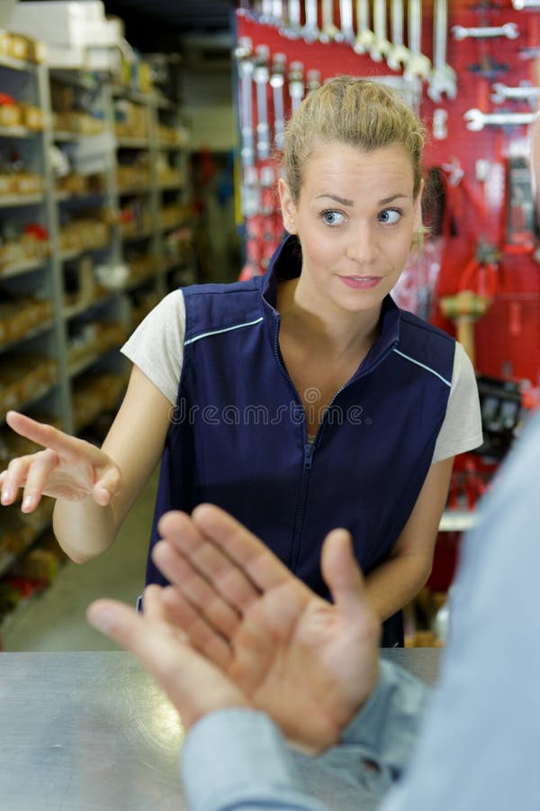 Female Workshop Worker Pointing Direction To Client Stock Photo - Image ...