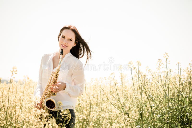 Femme Attirante Sexy Avec Le Saxophone Posant Sur Le Fond Rouge Jeune