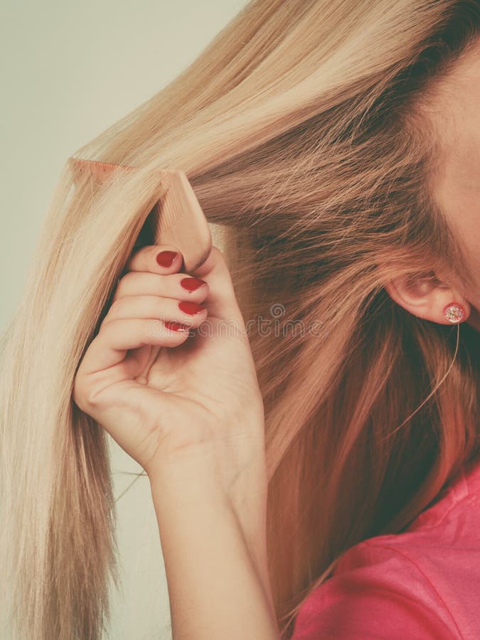 Femme Se Brossant Les Cheveux Blonds Dans La Salle De Bain Photo Stock