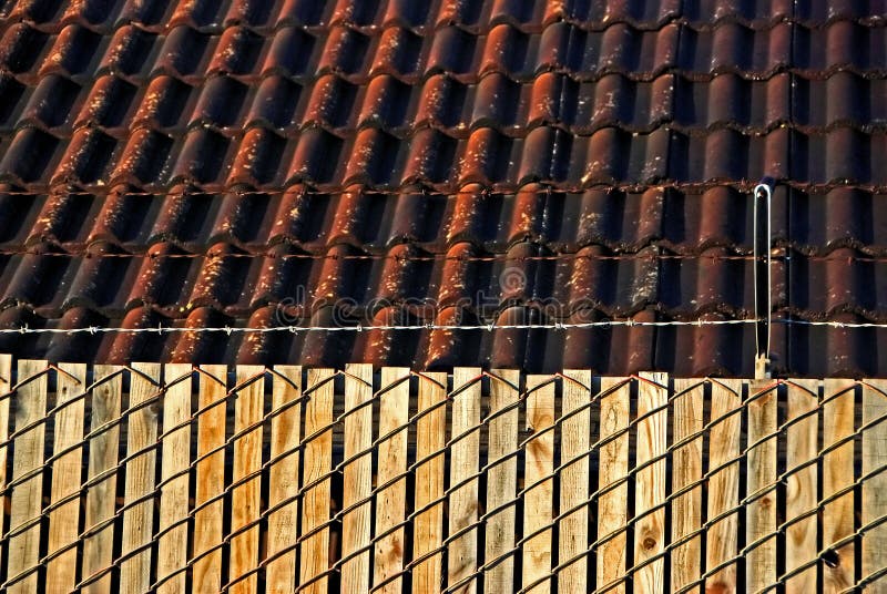 Fence, barb wires and roof stock photo. Image of tile - 11473560