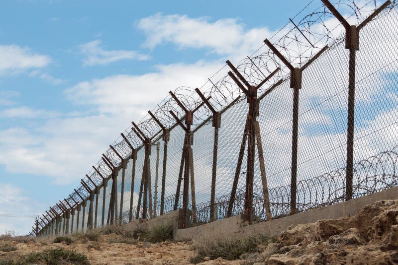 A Fence with Barbed Wire. a Long Wire Fence with Barbed Wire Stock ...
