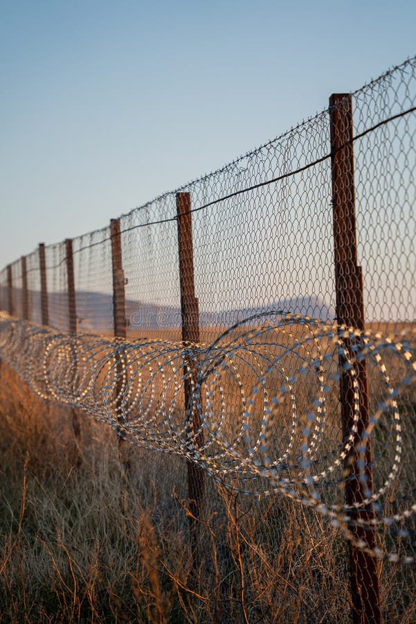 Fence with Barbed Wire and Mesh at Sunset. Private Territory. Barbwire ...