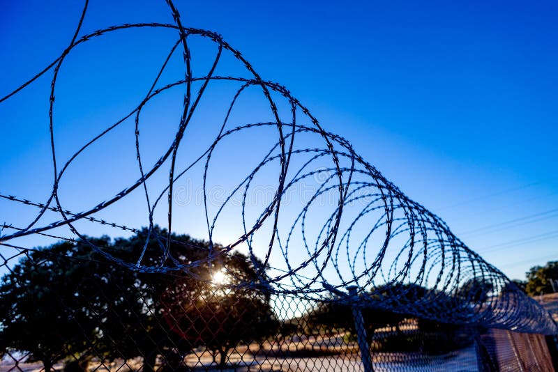 Fence with a Barbed Wire Under Stock Image - Image of blue, metal ...