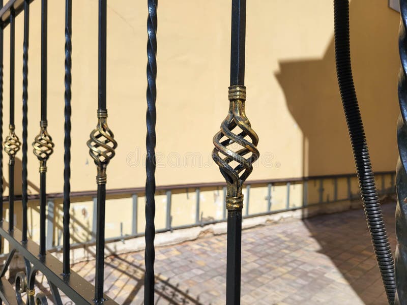 A Fence with Forged Bronze Elements on the Background of a Beige Wall ...