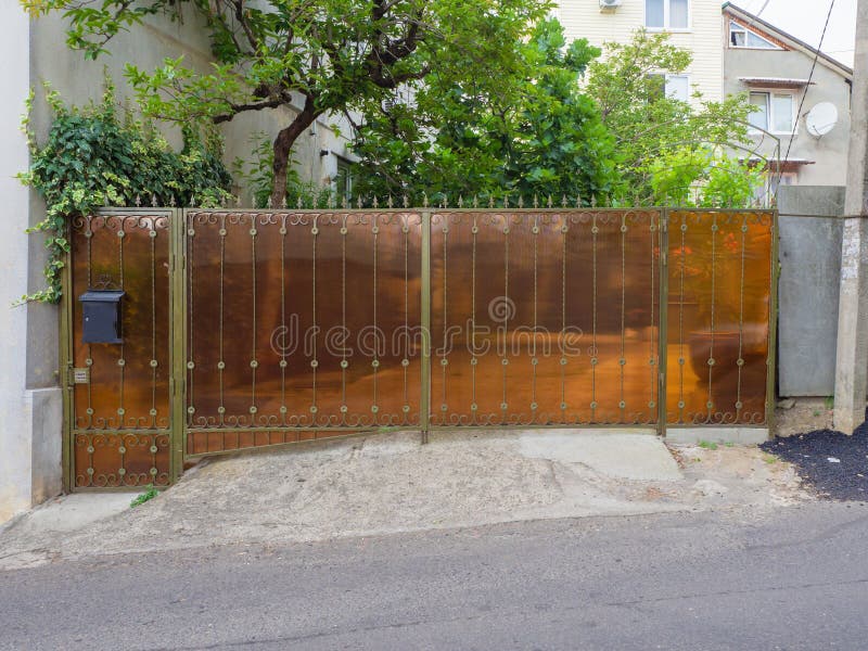 A Fence Made of Metal and Orange Translucent Plastic with a Forged ...
