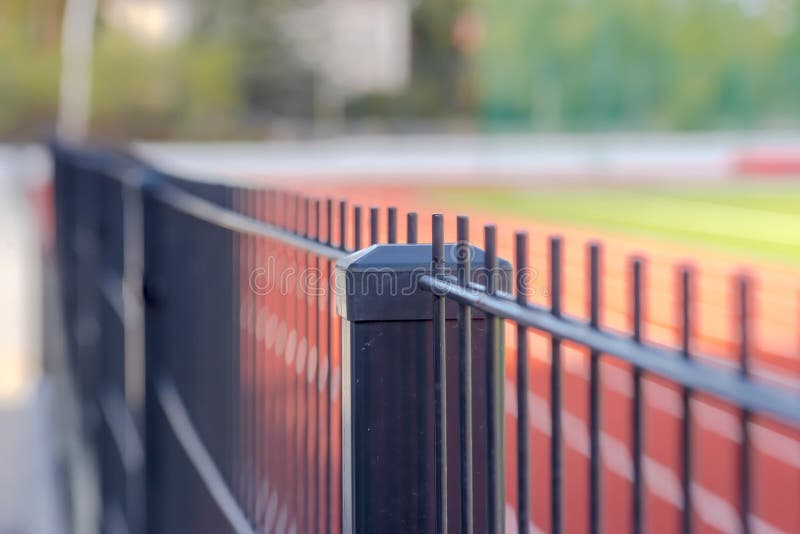 Fence Made of Thin Steel Bars Along the Sports Track. Stock Image ...
