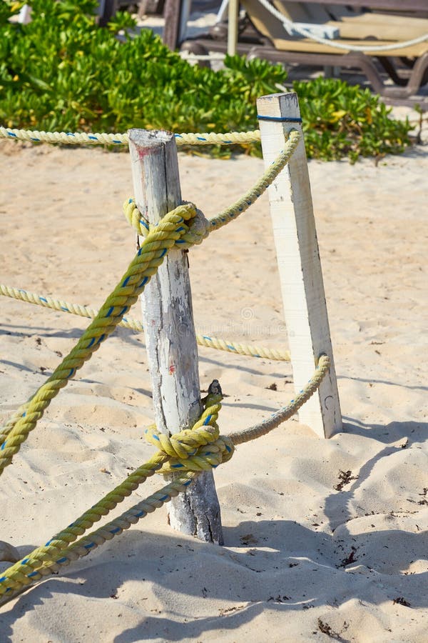 A Fence of Painted White Boards and a Yellow Rope in the Sand. Stock ...