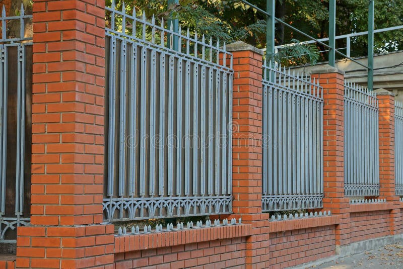 Fence Wall of Red Bricks and Gray Metal with Sharp Bars Stock Image ...