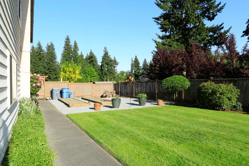 Fenced Back Yard with Green Lawn, Beds Stock Photo - Image of chairs ...
