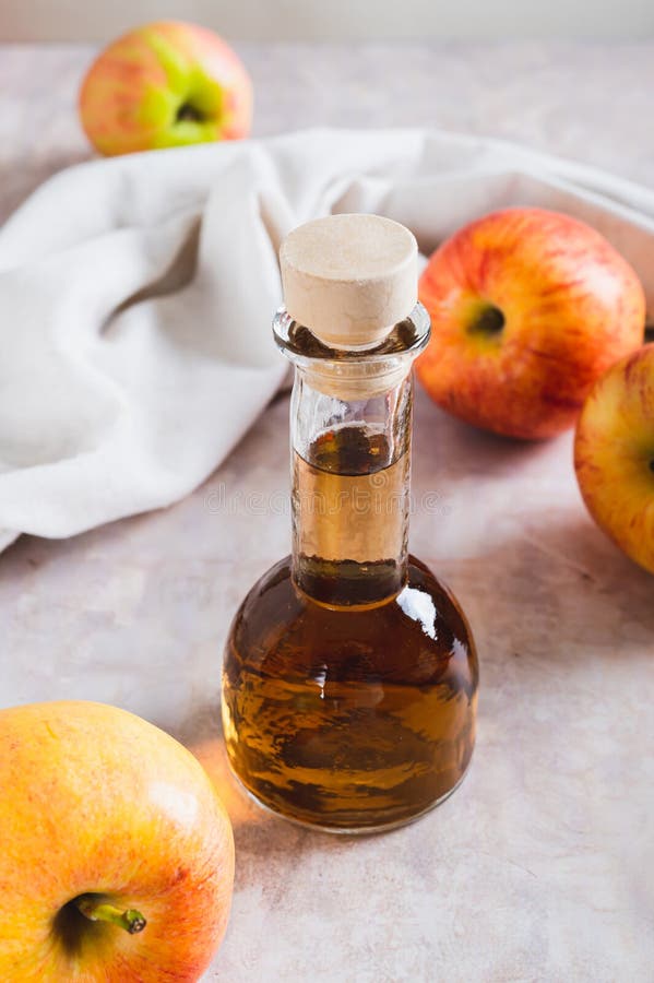 Fermented Apple Cider Vinegar in Glass Bottle and Fruits on Table ...