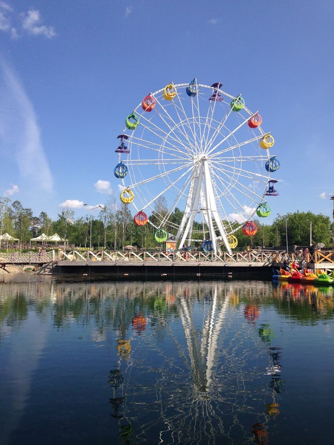 Ferris Wheel with Multi-colored Booths Reflected in the Water on Stock ...