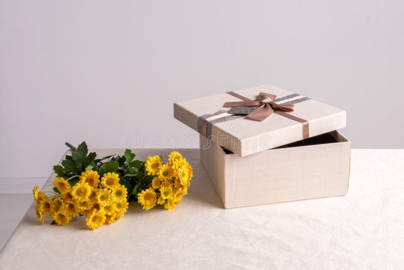 Festive Still Life: Gift Box and Yellow Flowers on the Table with a ...