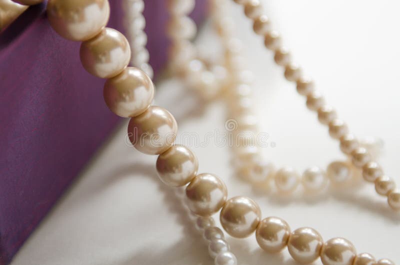 Few Beads of Pearls Hanging on a Purple Gift Box Stock Photo - Image of ...