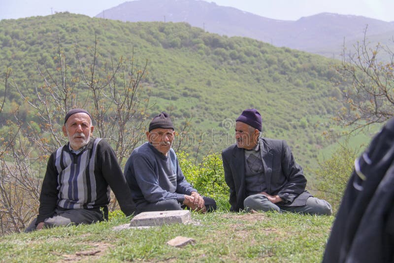 A Few Rural Men Sit on the Grass. Trees, Mountains and Forest are ...