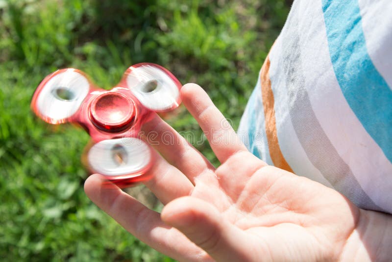 Fidget Red Spinner Stress in Hand. Young Boy Play with Red Fidget ...