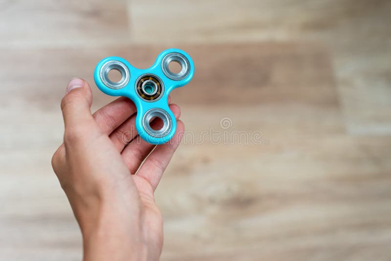 Fidget Spinner. Blue Hand Spinner, Fidgeting Hand Toy Rotating on Child ... Fidget Spinner. Blue Hand Spinner, Fidgeting Hand Toy Rotating on Child ...