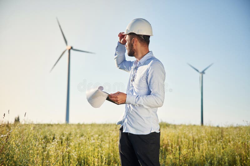 Handsome Service Engineer is Standing on the Field with Windmills Stock ...