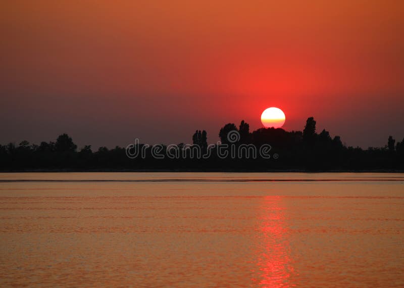 Fiery Sun Setting Over Island Reflecting on Sea Water Stock Photo ...