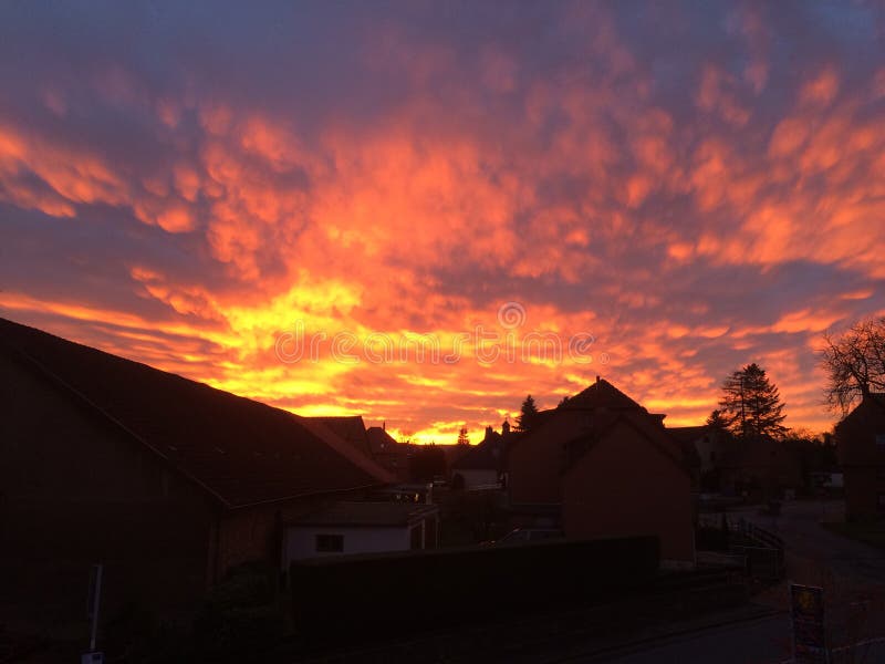 Fiery sunset over houses stock photo. Image of sunset - 88784512