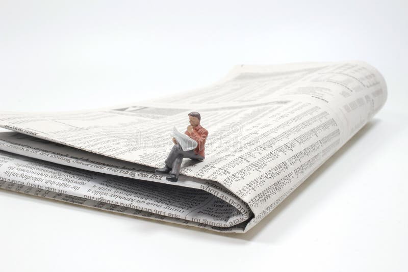 A Figure of a Man Reading a Newspaper while Sitting on a Full Size ...