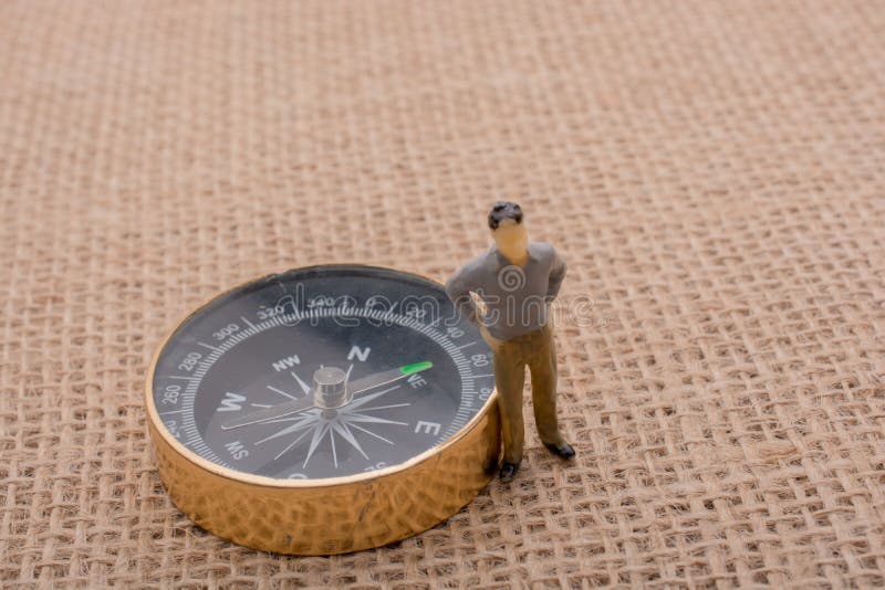 Figurine by the Side of a Compass Stock Image - Image of figurine ...