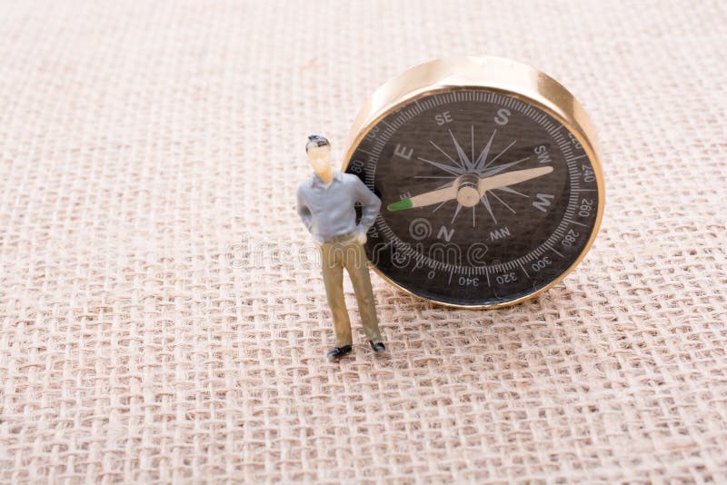 Figurine by the Side of a Compass Stock Photo - Image of nature ...