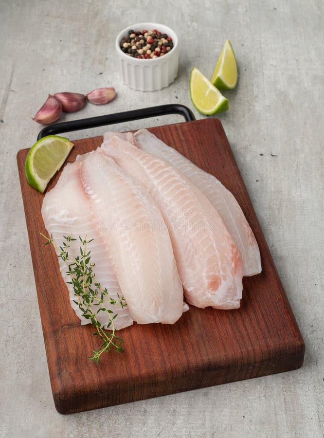 Filete De Pez Tilapia Crudo Con Condimentos Sobre Mesa De Madera Foto ...