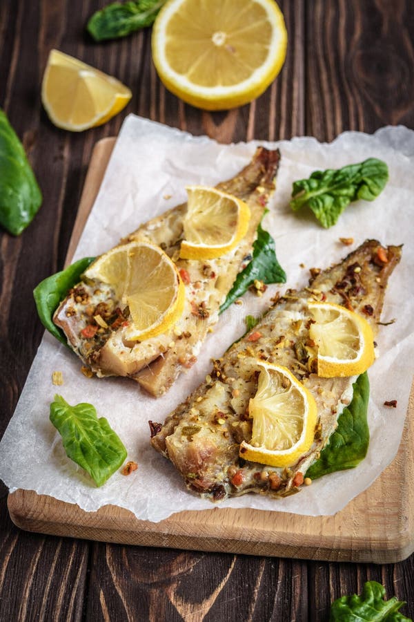 Filete De Pollock Cozido Com Limão E Espinafre Sobre Fundo De Madeira ...