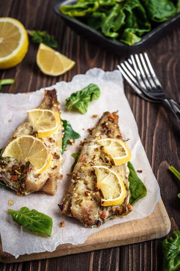 Filete De Pollock Cozido Com Limão E Espinafre Sobre Fundo De Madeira ...