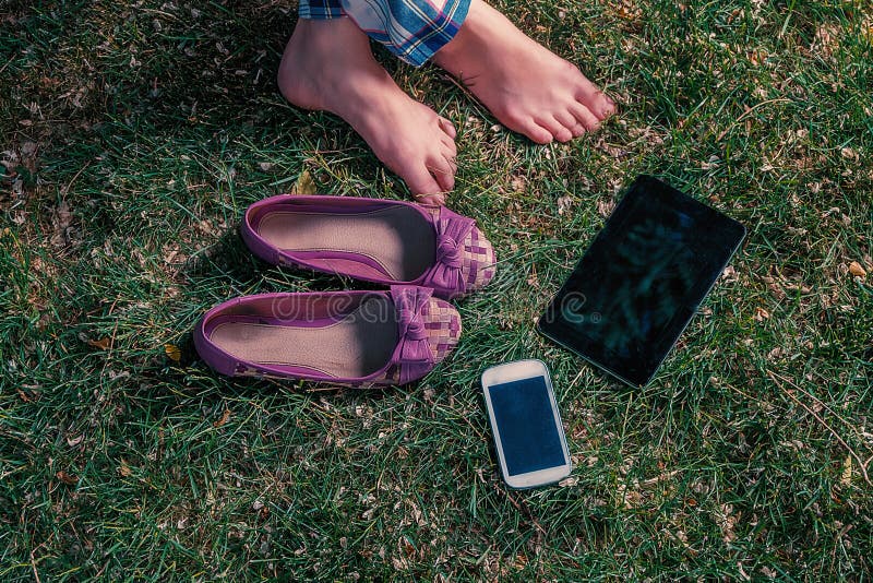 Fille Aux Pieds Nus Sasseyant Sur Lherbe Avec Le Tablette Pc Et Le