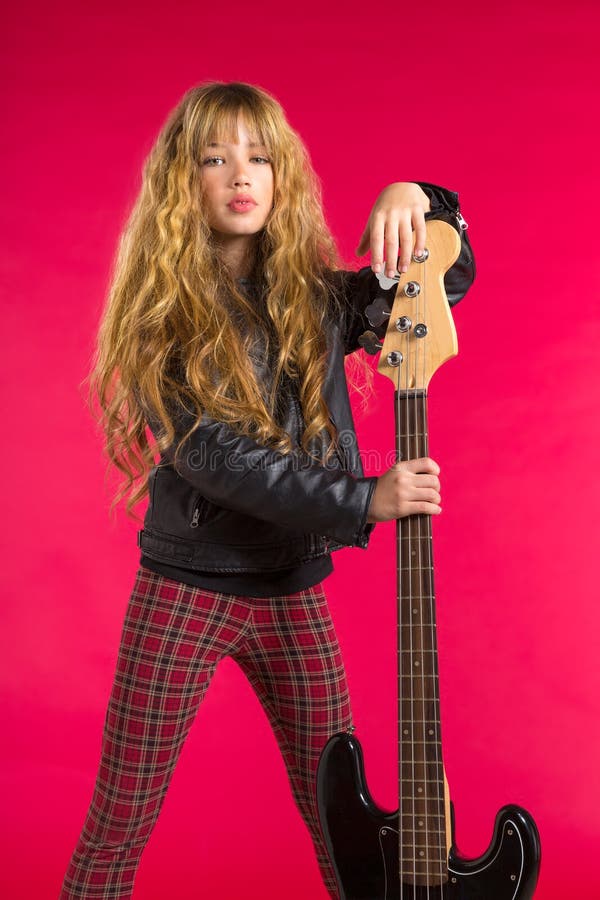 Fille Blonde De Rock Avec Le Saut De Guitare Basse Sur Le Rouge Photo