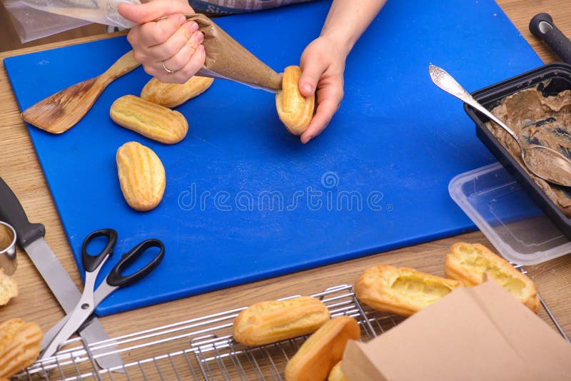 Filling Eclair Preparing on Kitchen Table with Kitchenware, Top View ...
