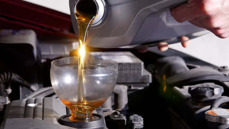 Filling Engine Oil Shining in the Rays of the Sun into a Car Engine ...