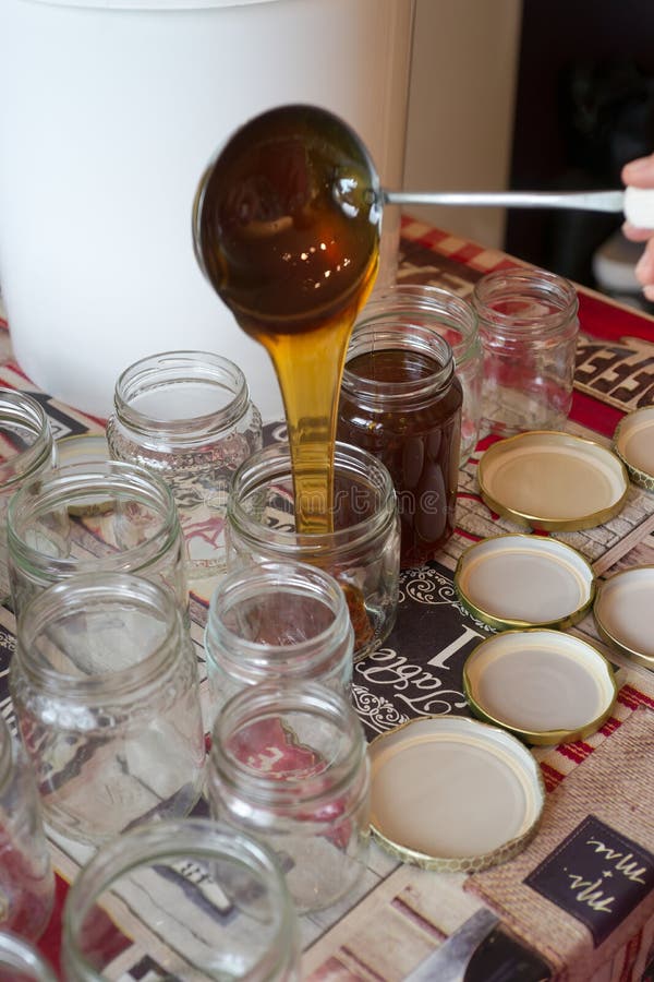 Filling of Glass Jars of Honey on a Table Stock Photo - Image of ...