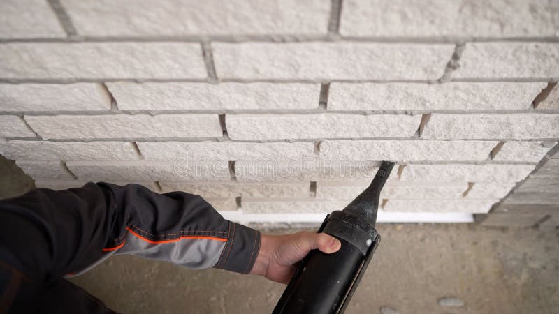 Filling the Joints between Bricks on the Facade of the House. Poor ...
