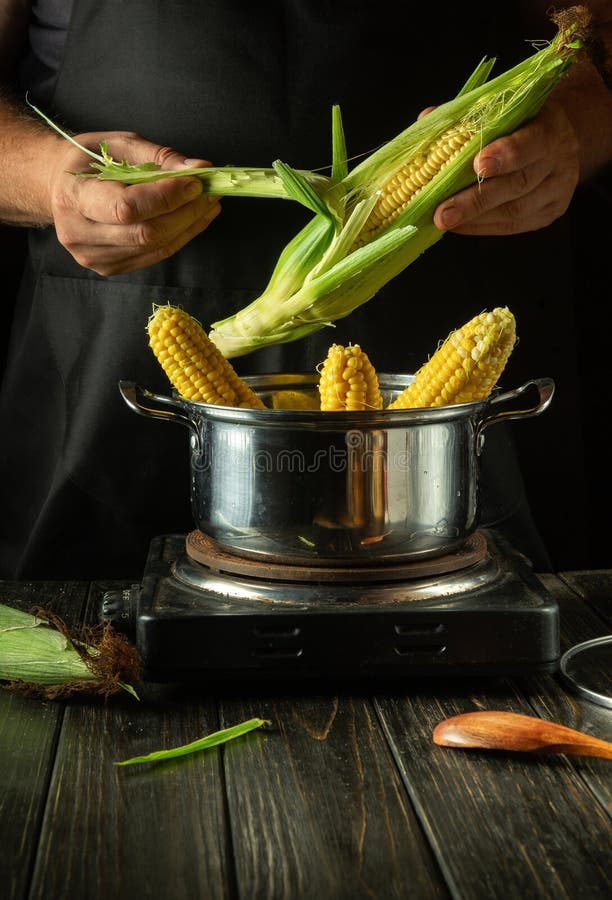 Filling a Pot with Raw Corn Cobs before Cooking. Concept of Cooking ...