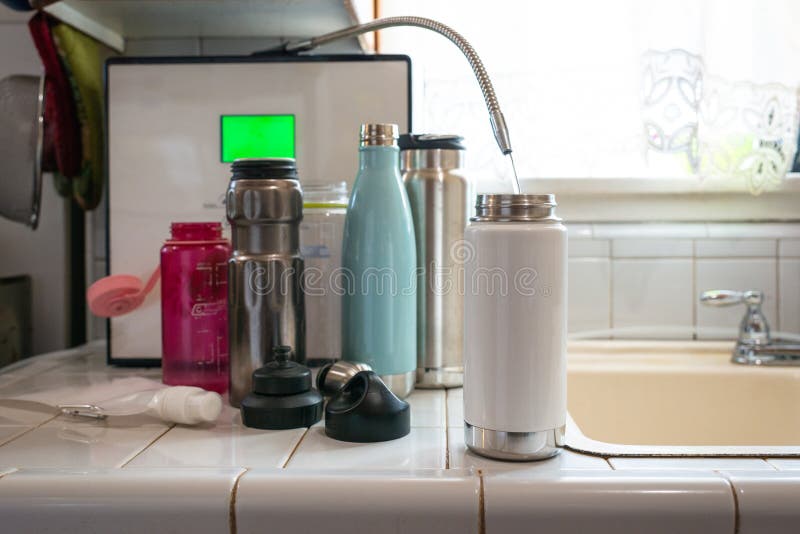 Filling Up Reuseable Water Bottles for the Family Stock Photo - Image ...