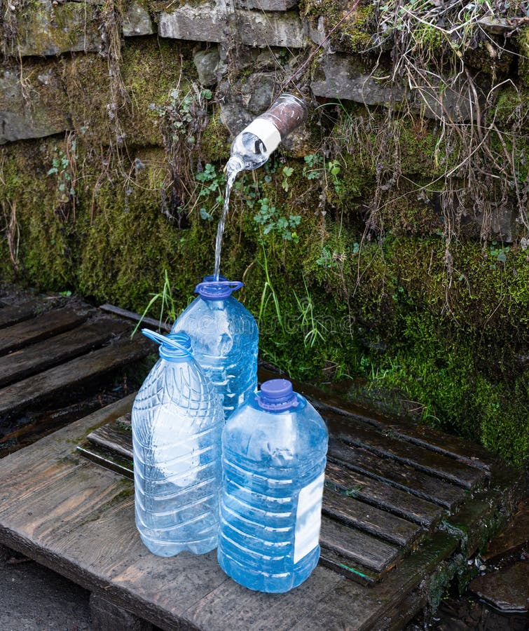 Filling Water from Mountain Stream into Plastic Cans Stock Image ...