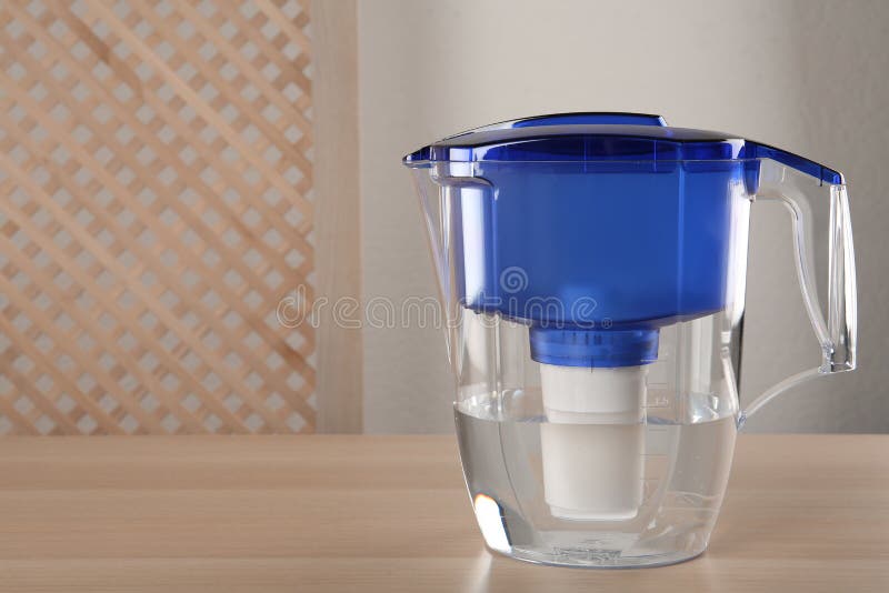 Filter Jug with Purified Water on Wooden Table Indoors. Space for Text ...